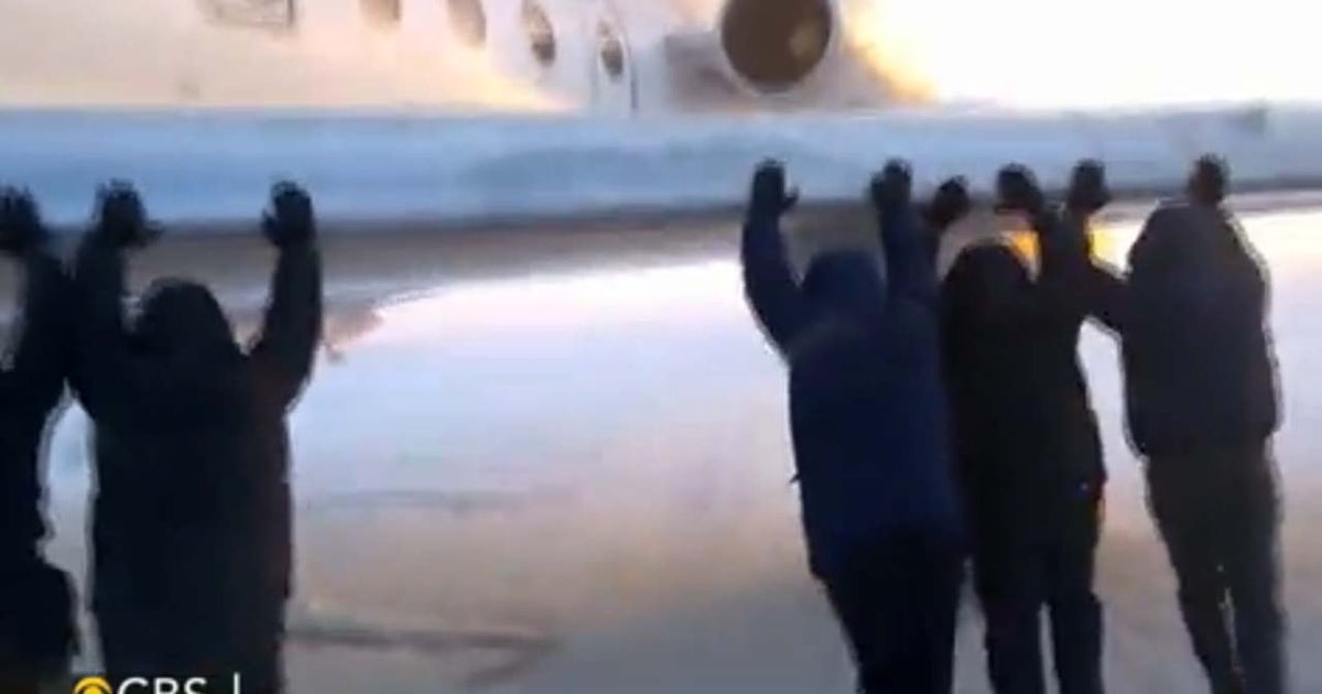 Russia passengers push frozen plane in Arctic - CBS News