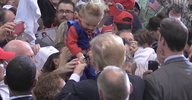 Donald Trump autographs crowdsurfing baby at campaign rally - CBS News