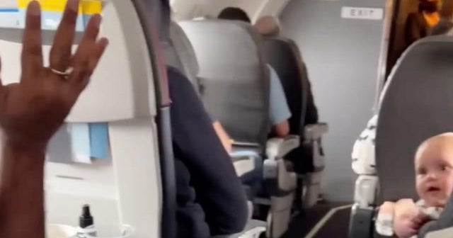 Stranger helps calm crying baby on flight - CBS News